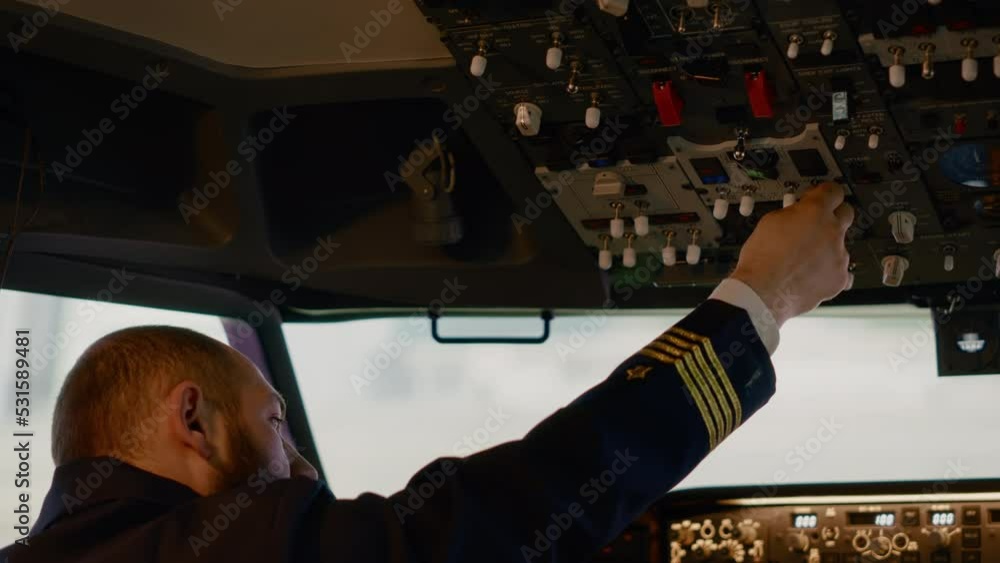 Stockvideon Airplane captain starting engine with power buttons on ...