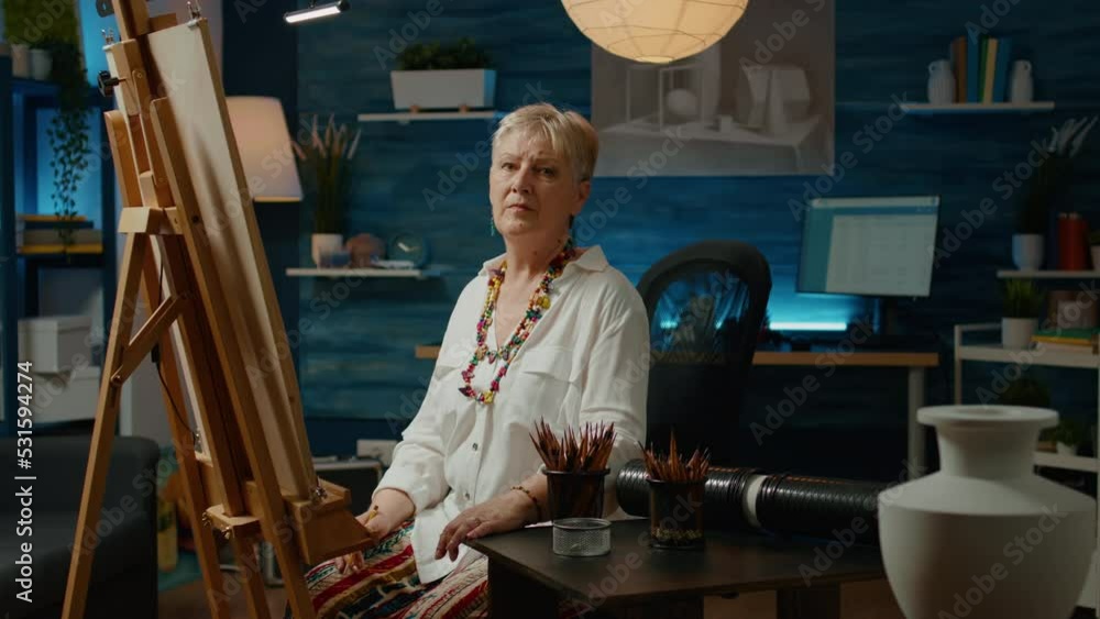 Portrait of senior artist drawing vase model on white canvas, using ...