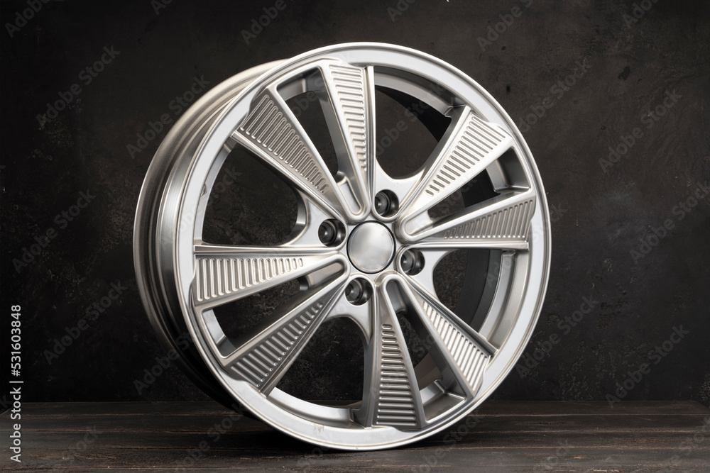 new grey alloy wheels on a dark textured black background. a wheel for ...