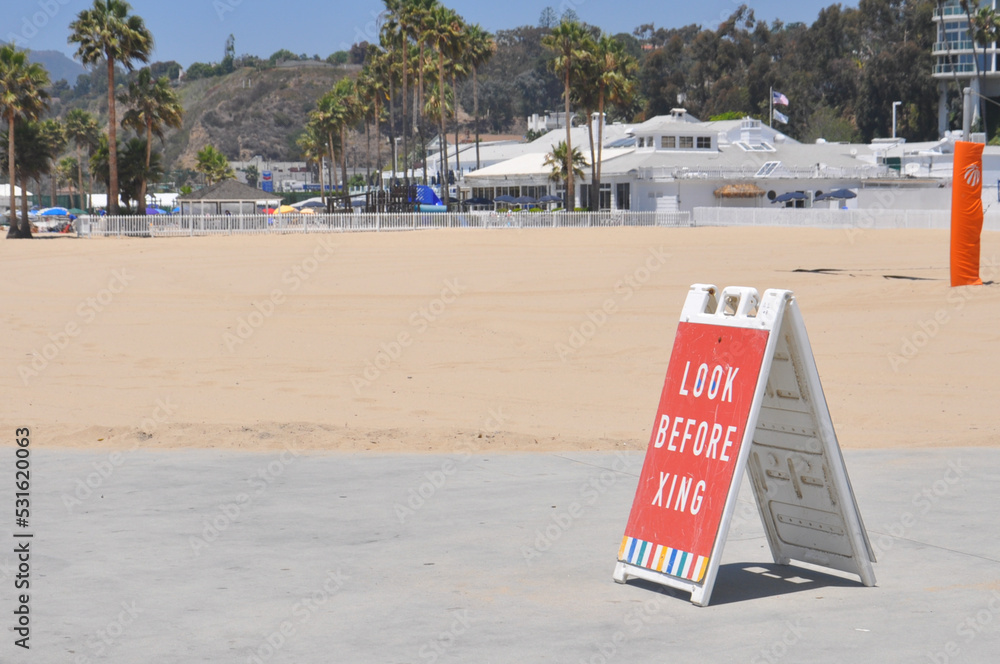 ped xing sign in a red background, sign on the sand, on the beach, look ...
