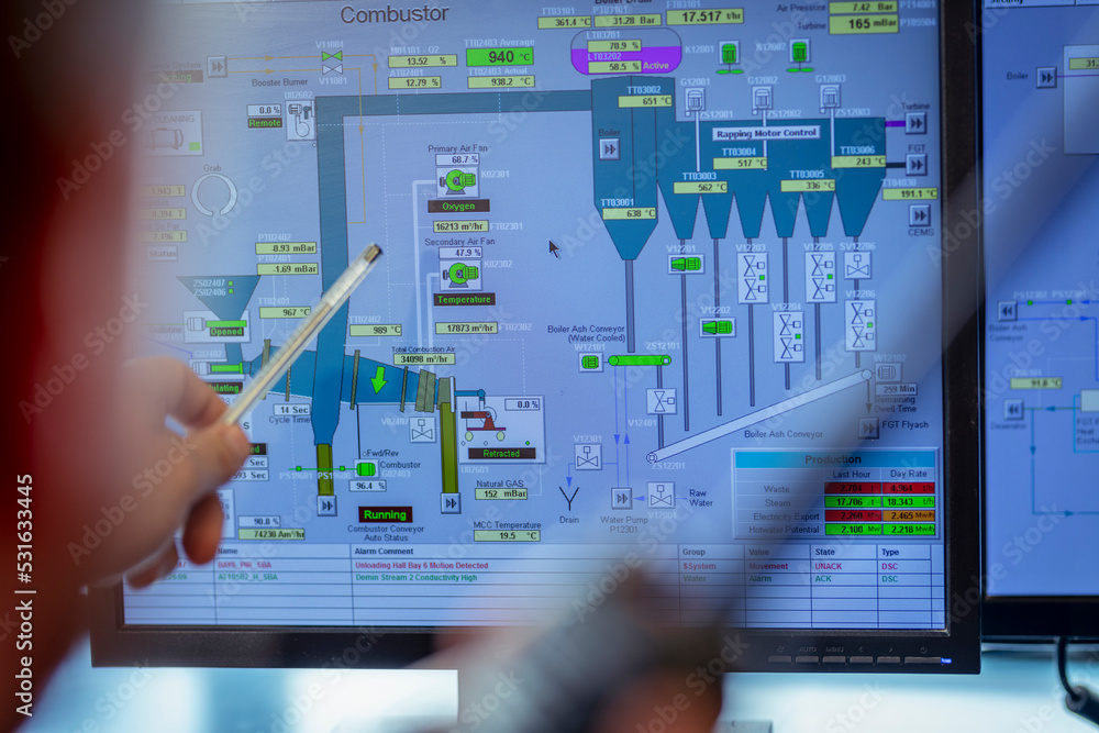 Worker monitoring waste to energy power station equipment on screen ...