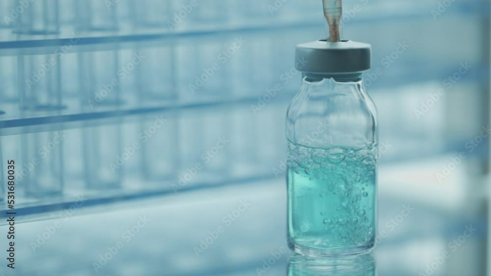 A doctor is filling phial bottle with an injection for vaccination from ...