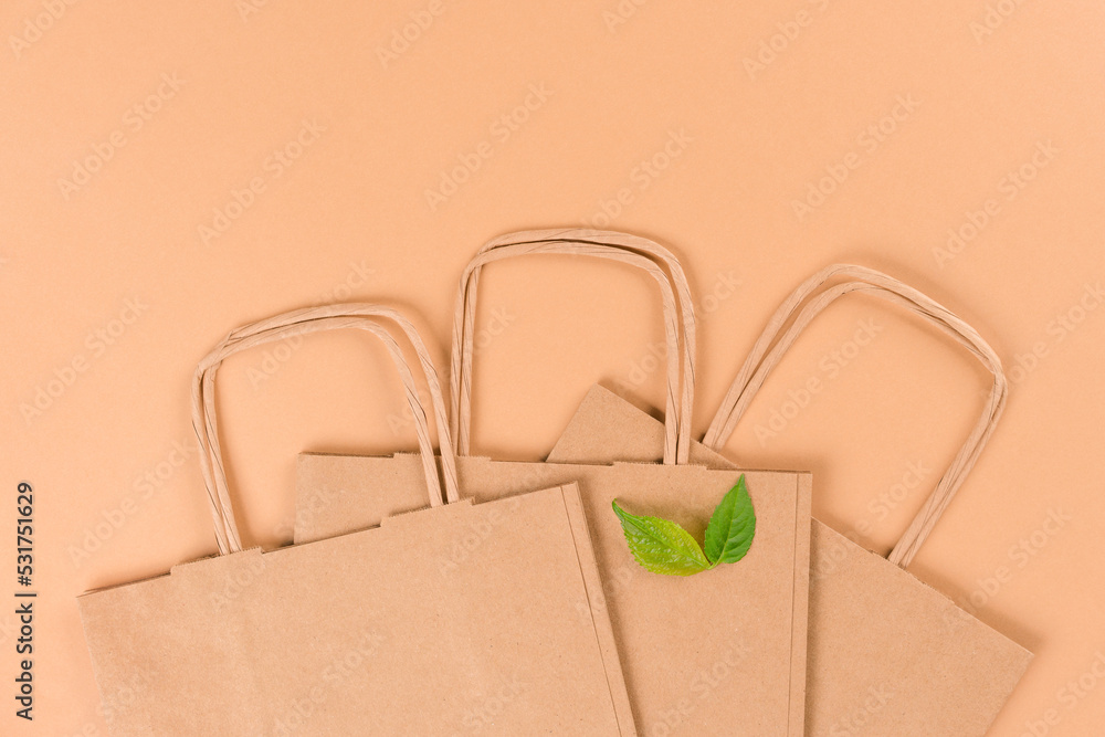 Paper shopping bags over light brown background with copy space. Green ...