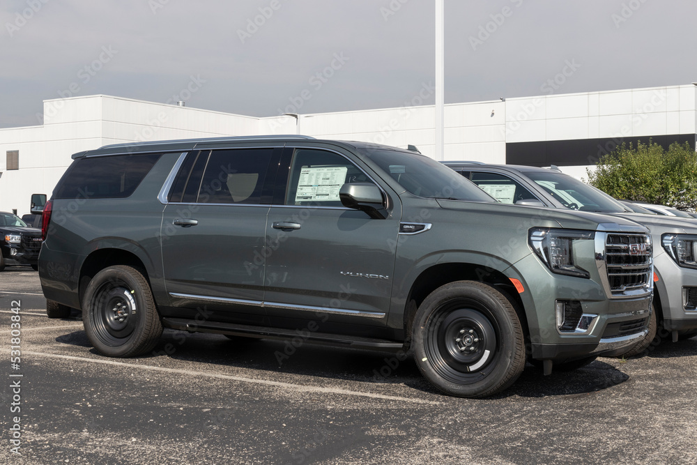 GMC Yukon SUV truck display at a dealership. GMC offers the Yukon in ...