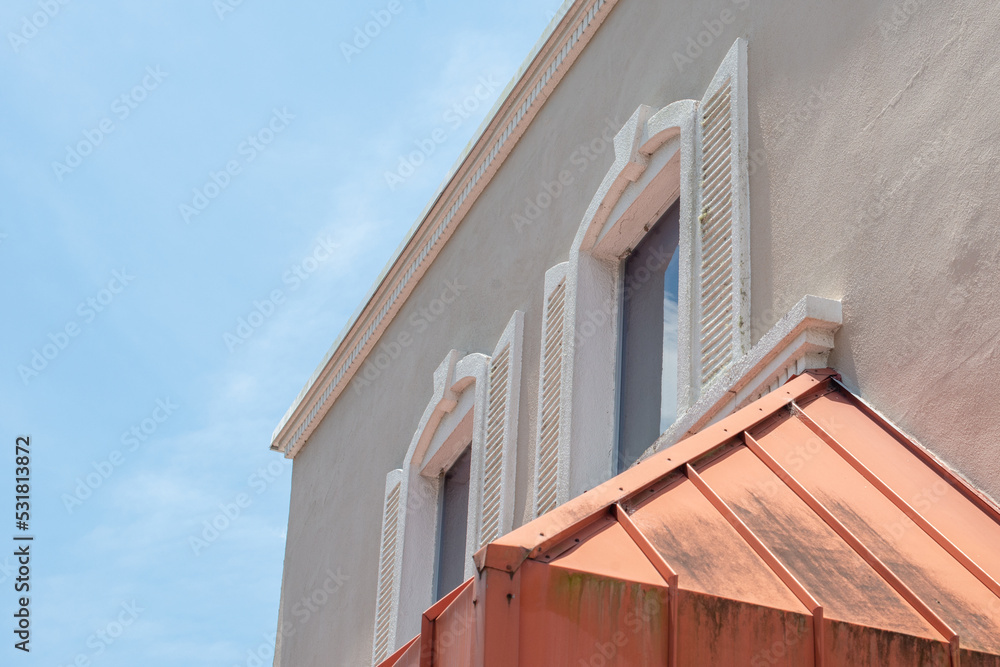 Two long glass windows with curved stucco trim over the openings. The ...
