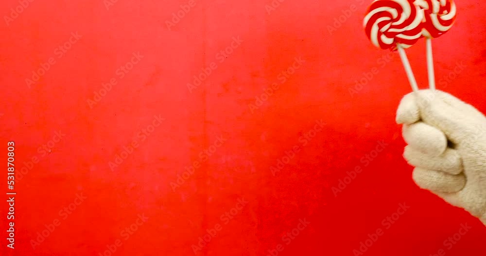 Two striped round candies are depicted on an outstretched hand in a ...