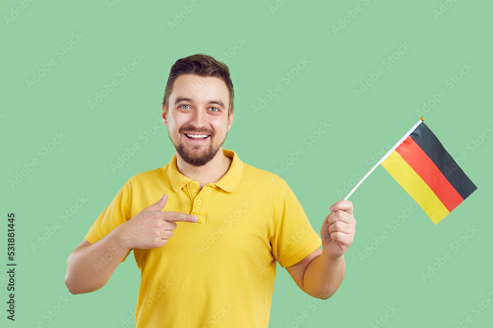 Happy man standing isolated on green background, holding flag of ...