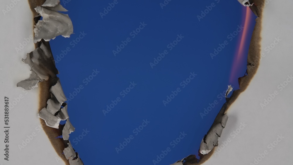 White paper is on fire. The sheet of paper burns, exposing the burnt ...