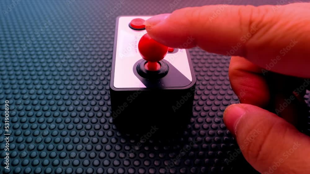 remote control on dark background, red button, finger presses red ...