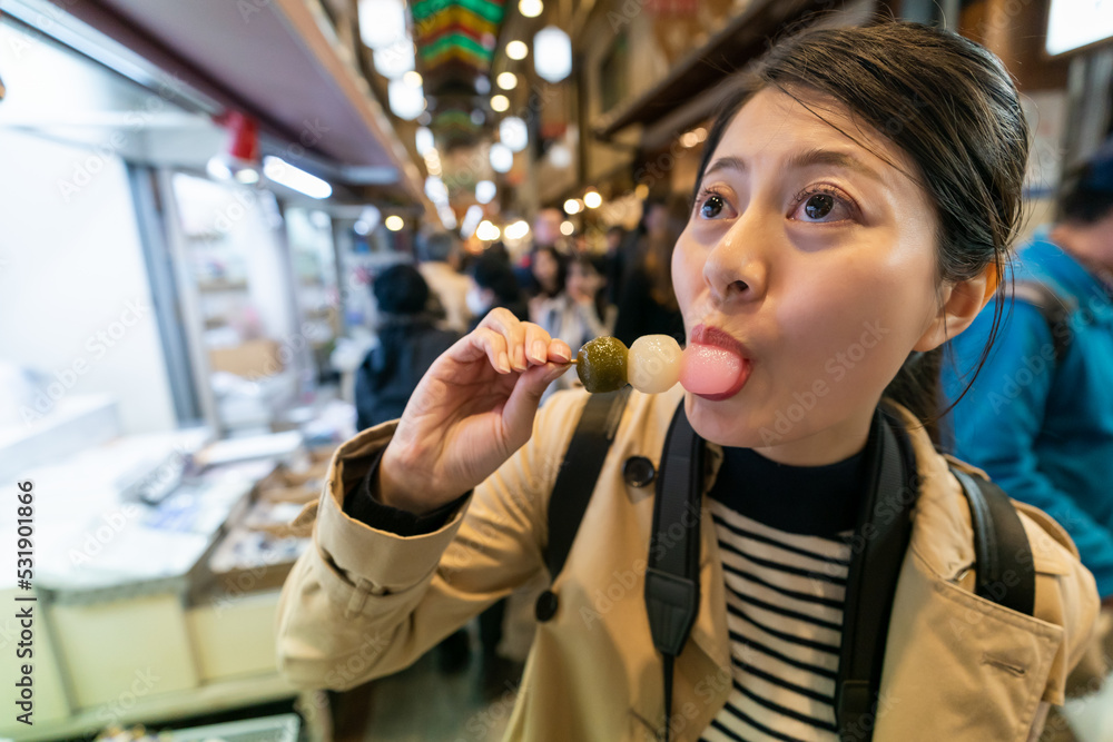 closeup portrait of asian Chinese female visitor biting into yummy ...