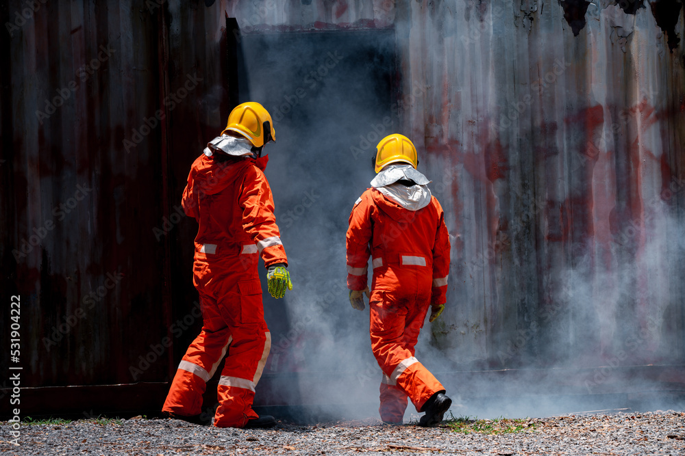 Firefighter with fire suite standing in front of frightening explosion ...
