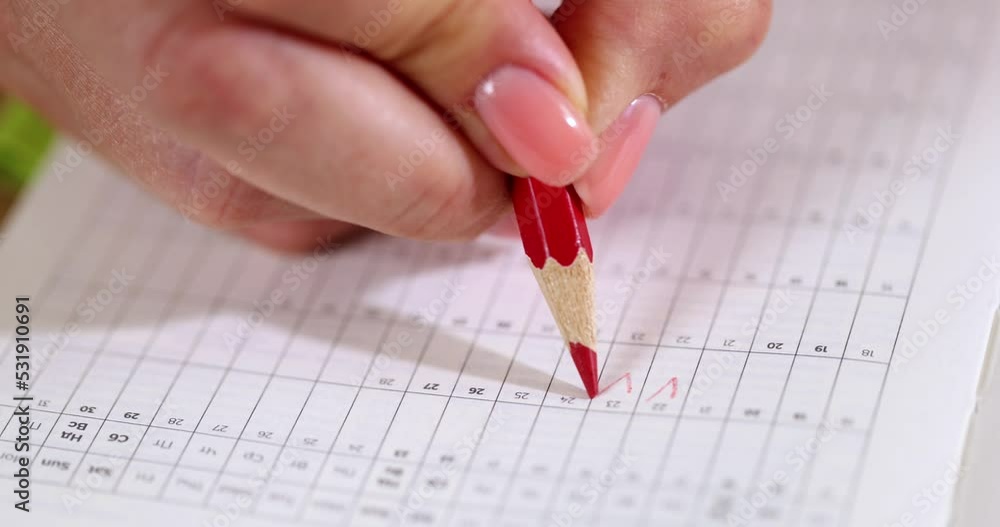 Female hand marks days of menstrual cycle in calendar with red pencil ...