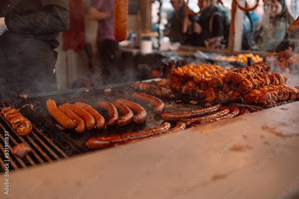 Blurry background of bbq street food for sale. Fried baked sausages ...