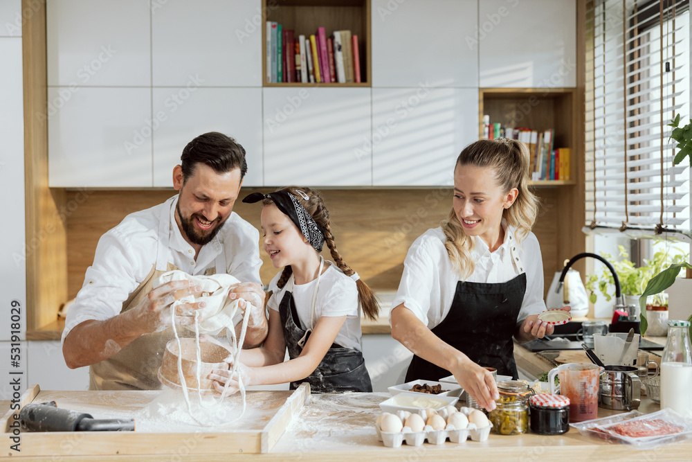 Curious daughter holding sive above wooden surface happy father pouring ...