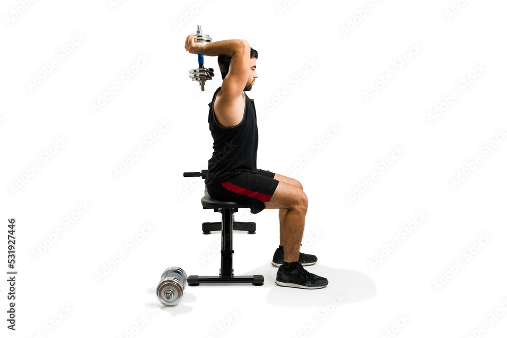 Side view of a sporty man exercising doing tricep dips using weights ...