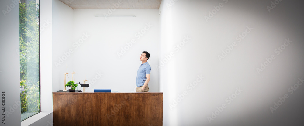 Thoughtful male engineer standing behind desk in office Stock Photo ...