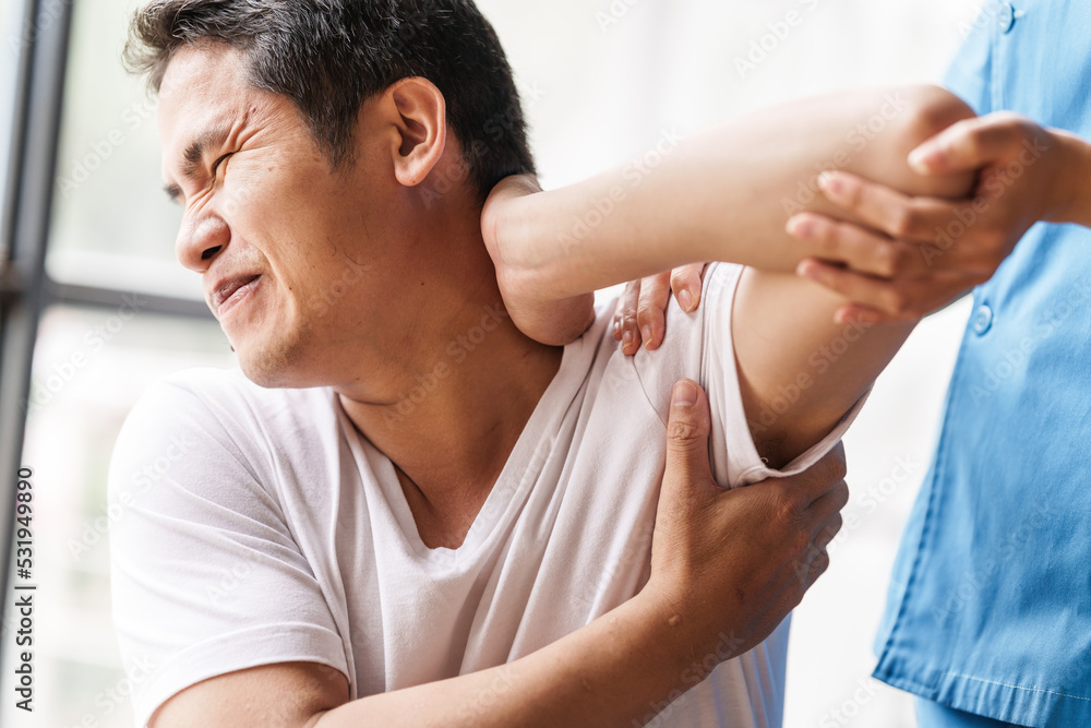 Physical therapist is examining the injured arm, waist and neck muscles ...