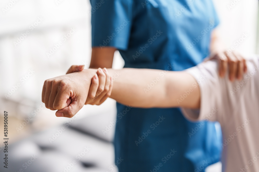 Physical therapist is examining the injured arm, waist and neck muscles ...