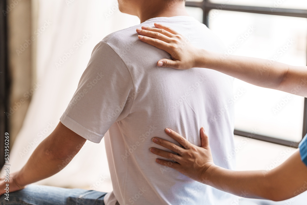 Physical therapist is examining the injured arm, waist and neck muscles ...