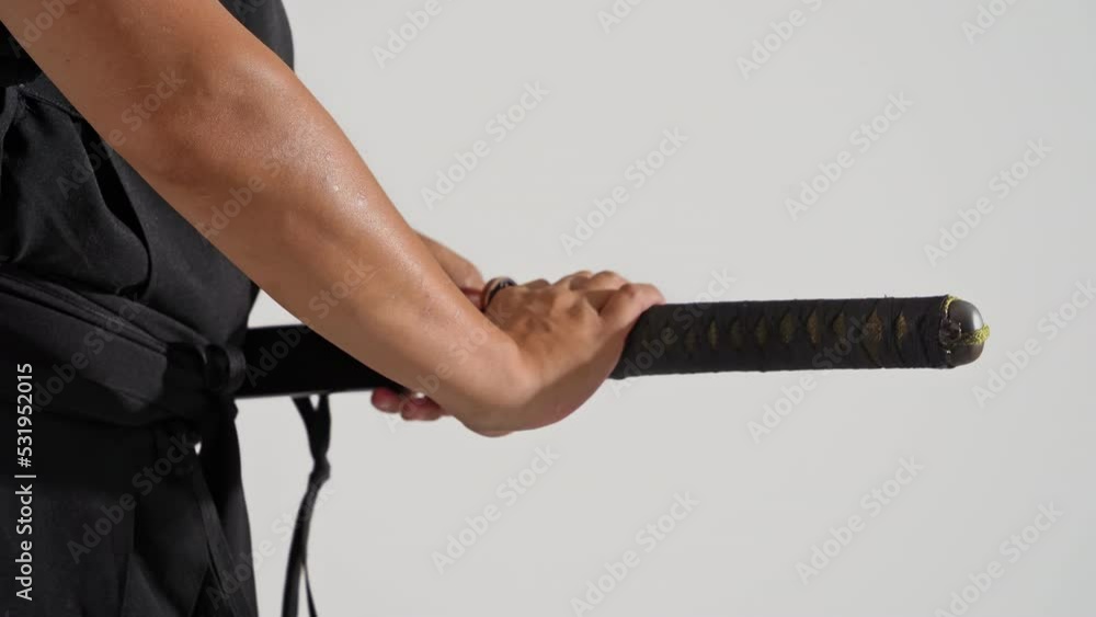 Japanese traditional dress pulls out katana sword scabbard. Shows shiny ...