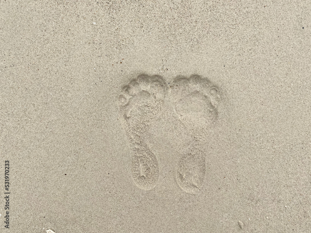 Woman footprint stamp on sand ground at the beach. Rough surface ...