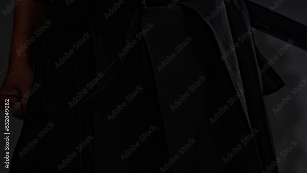 Japanese, black traditional kimano samurai, wars, touches sheath katana, runs fingers along ...