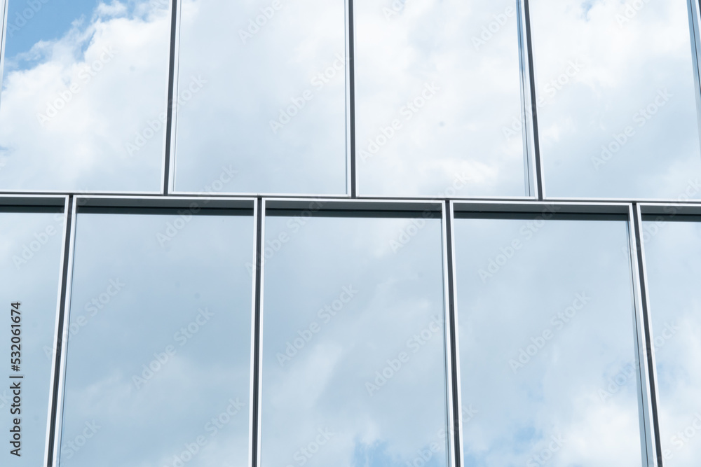 Blue skies reflected in architectural window modern design glass ...