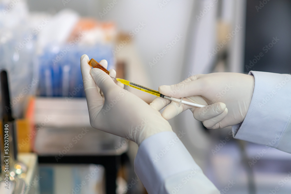 Soft focus vial and syringe on hand of a nurse,doctor administer the ...
