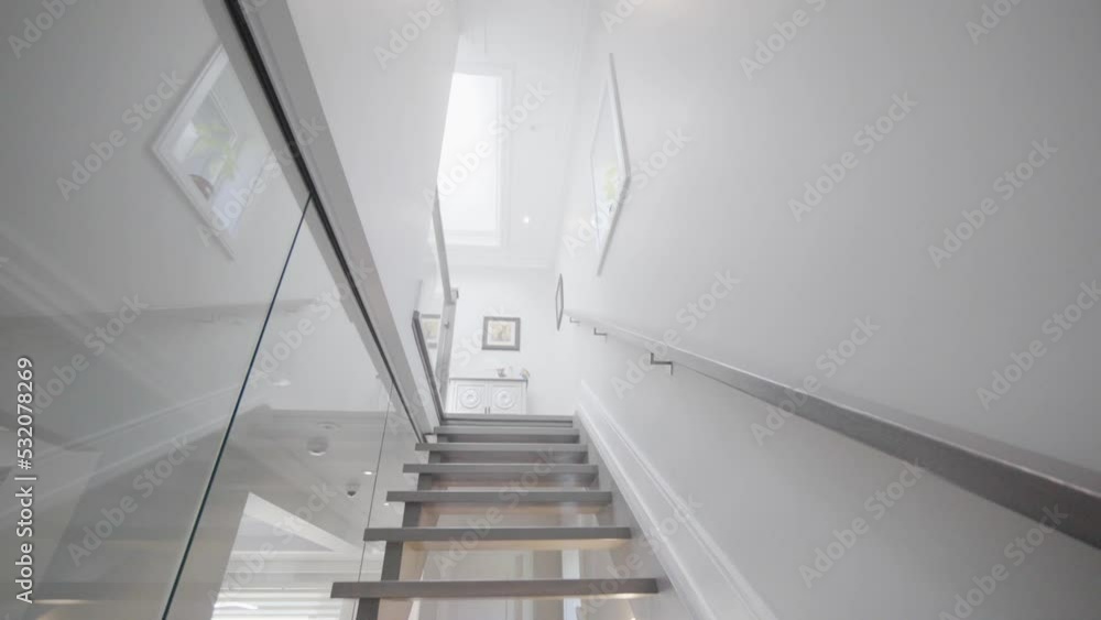 Going upstairs through a see through glass stair wall in a tilt cemara ...