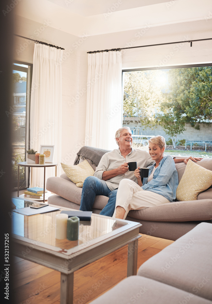 Senior couple with coffee or tea and relax on sofa in their living room ...