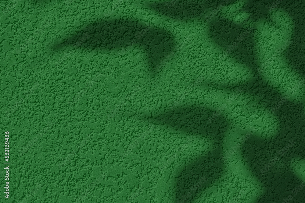 Abstract tree leaves shadows on dark green concrete wall texture with ...