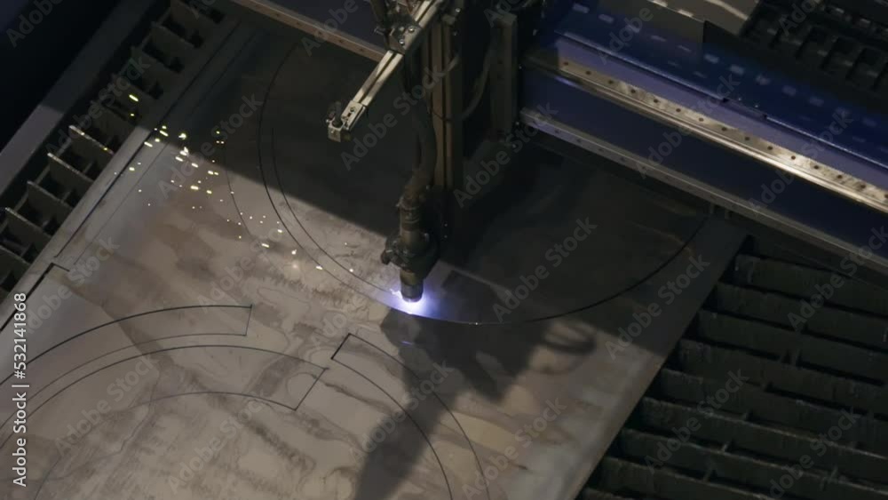 Automated laser machinery cutting the circular shape from the steel ...