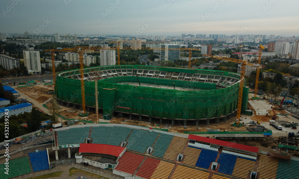 Building a stadium in a big city. Construction site among urban areas ...