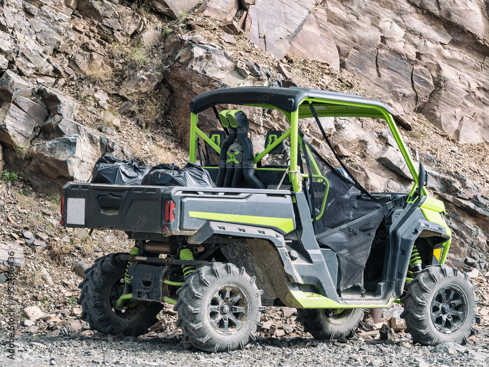 All-terrain four-wheeler vehicle. Off-road quad at rock background ...