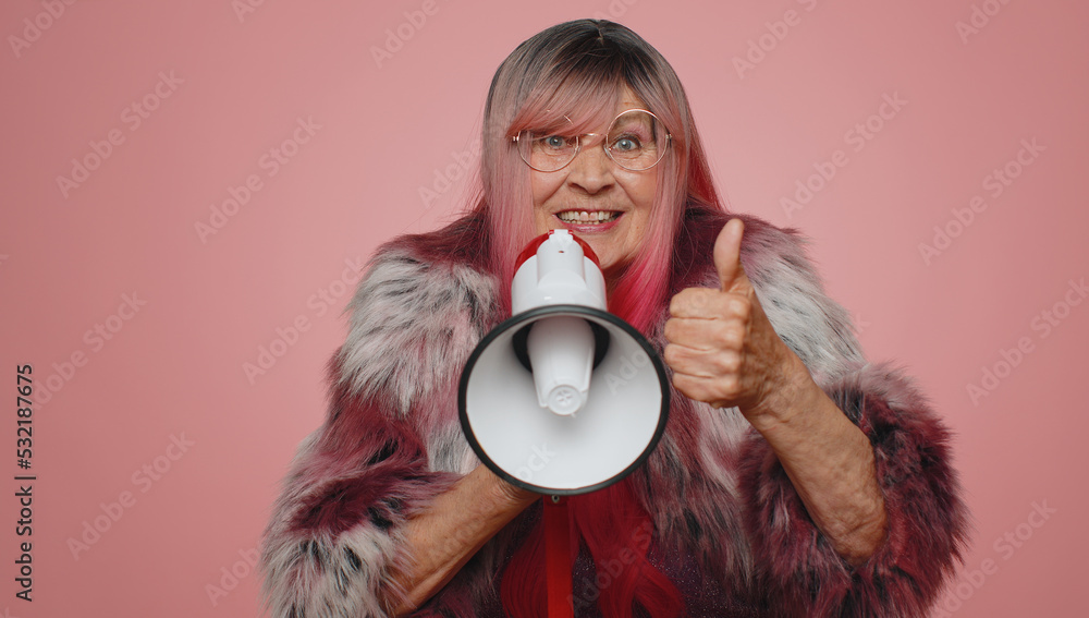 Smiling happy stylish old woman talking with megaphone, proclaiming ...