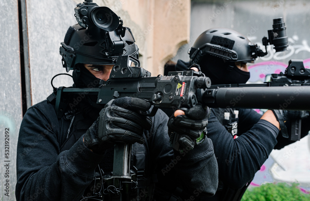 Anonymous squad fighters with rifles aiming near shabby building Stock ...