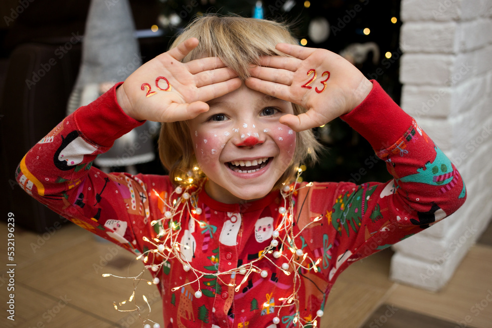 smiling cheerful child in a festive make-up of a deer, numbers of new ...