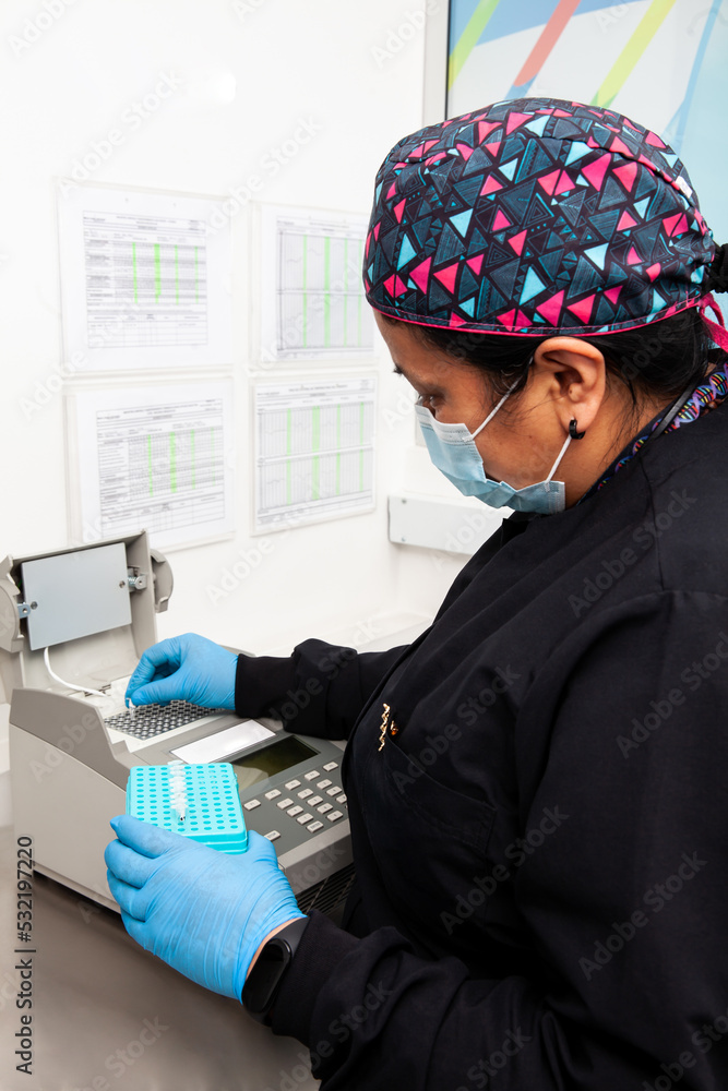 Female scientist working at the laboratory with a thermal cycler ...