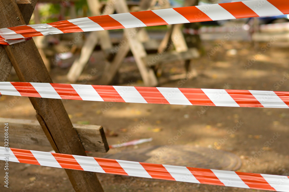 Red and white warning tape stretched across a blurred background with ... Red and white warning tape stretched across a blurred background with ...