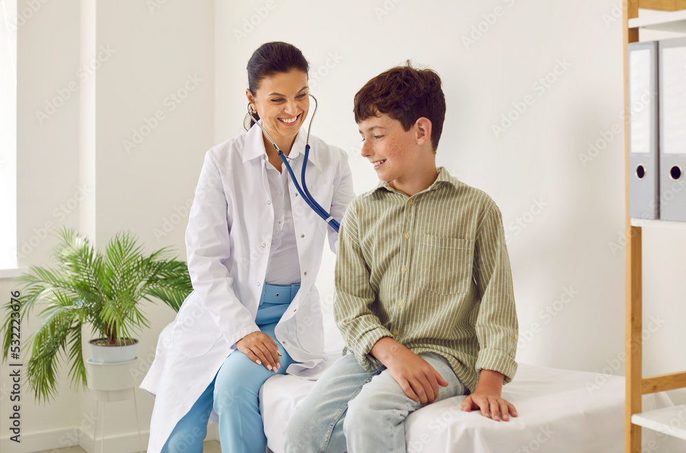 Happy child getting a professional health checkup at the doctor's office. Pediatrician sitting ...