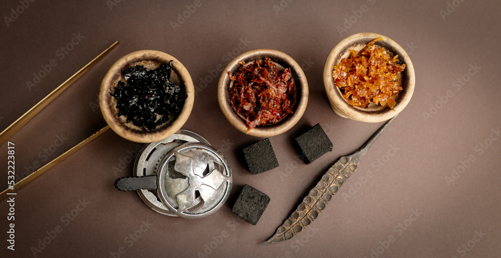 Three hookah bowls with aromatic tobacco on a brown table with smoking ...