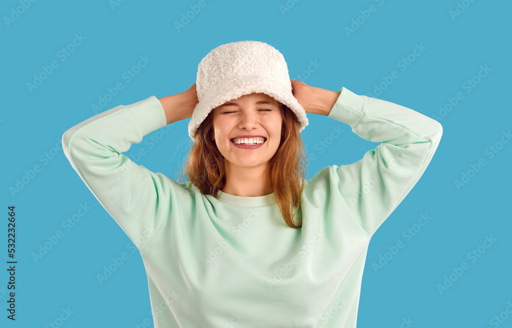Laughing carefree joyful young woman in white warm hat and mints ...