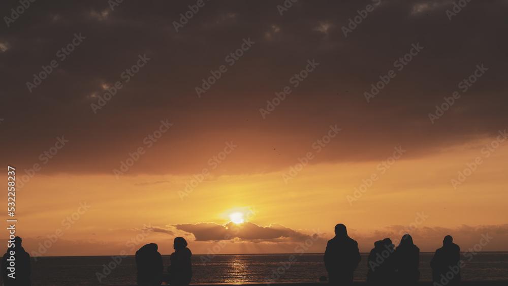 Silueta de un grupo de personas a contraluz en un atardecer en avenida ...