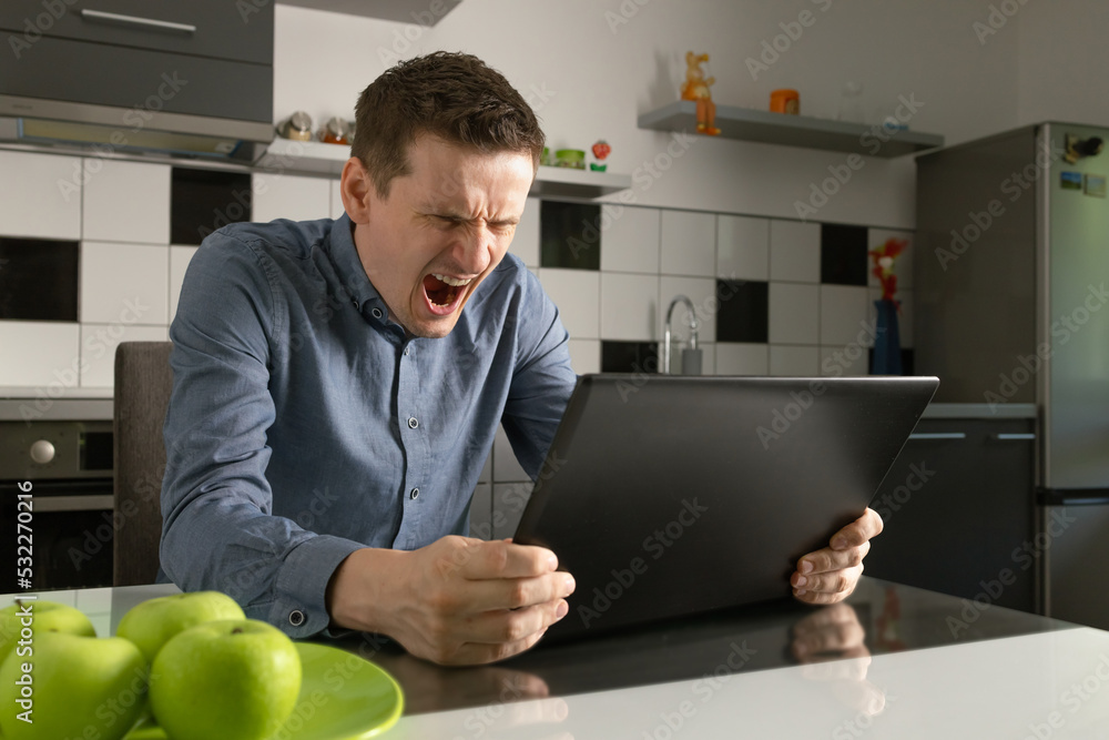 Laptop problem. Entrepreneur angry and furious with a laptop at home ...