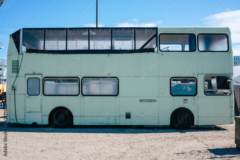 Mint-colored double-decker bus in a parking lot in summer. Old two ...