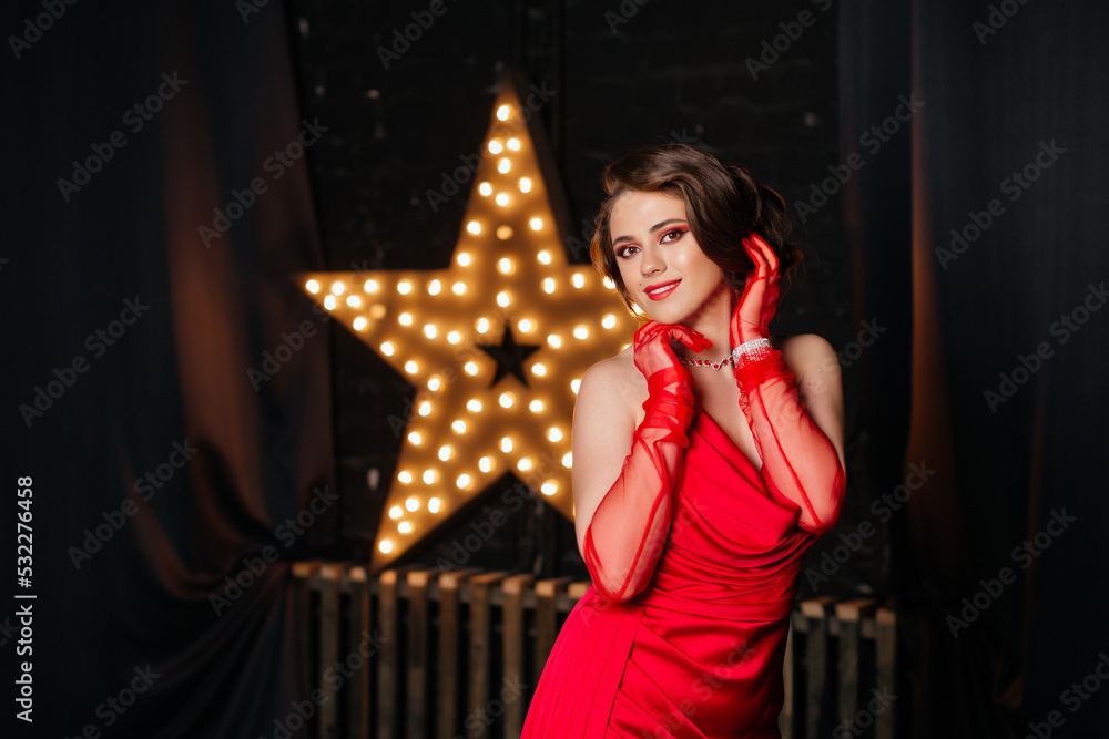 Sexy young girl singer sings into a silver retro microphone in a red ...