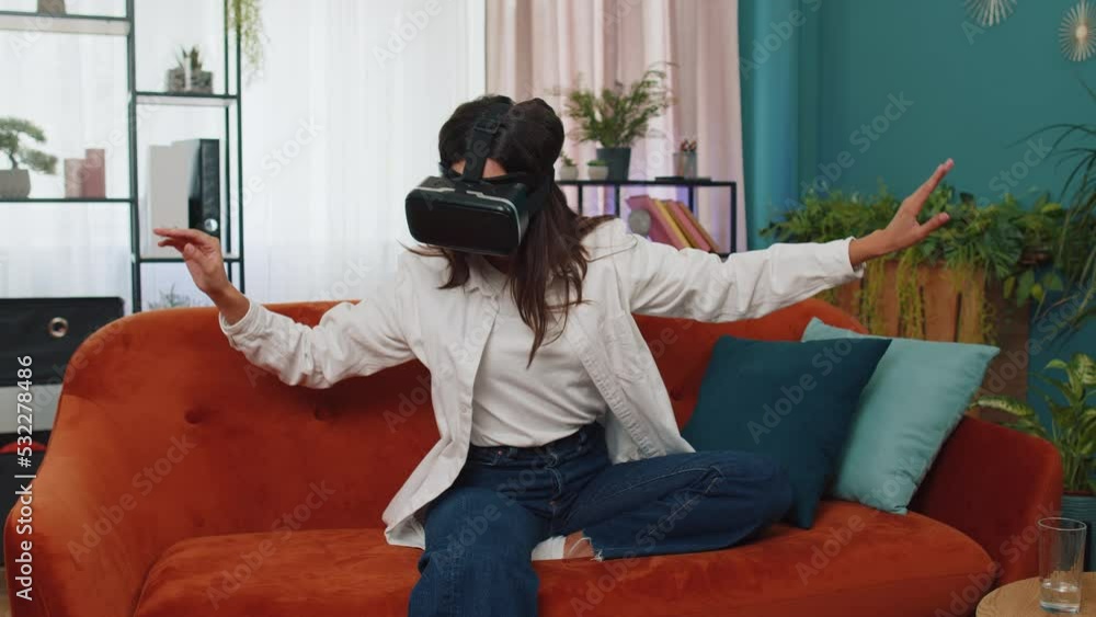 Young woman use VR headset glasses at home, enjoying 3D 360 video ...