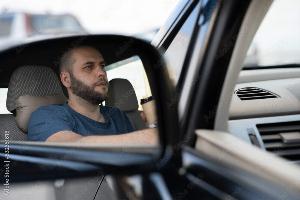 Serios man driver in car side view mirror, making sure lane is free ...