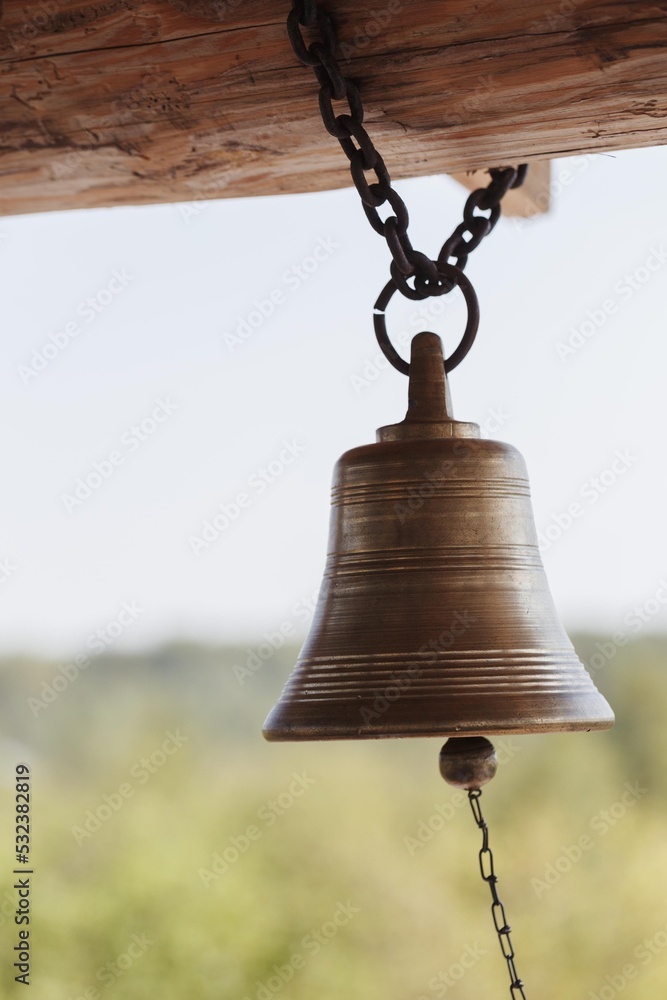 Vintage signal cast bell on the tower of a medieval outpost, vertical ...