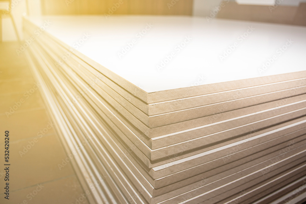 a stack of mdf panels neatly stacked in a cabinetry shop, background ...